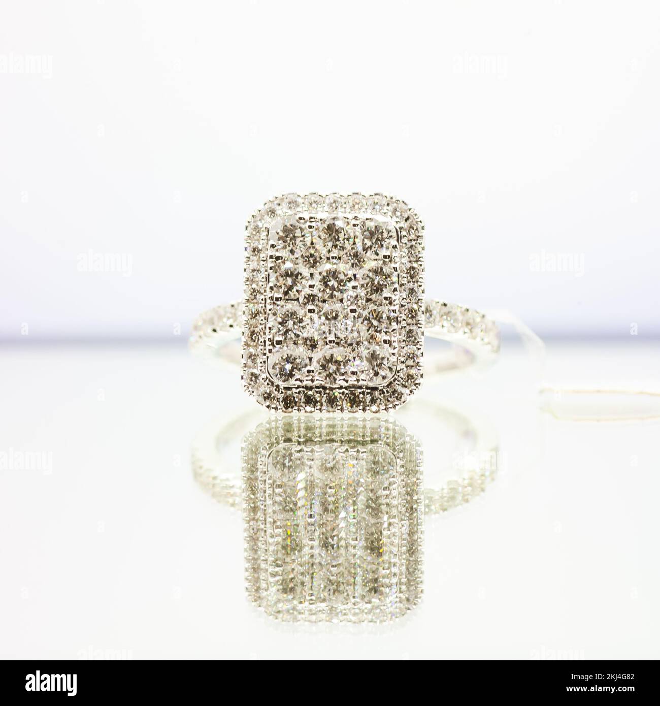 Engagement diamond ring on a mirror surface. emeralds, sapphires, and ...