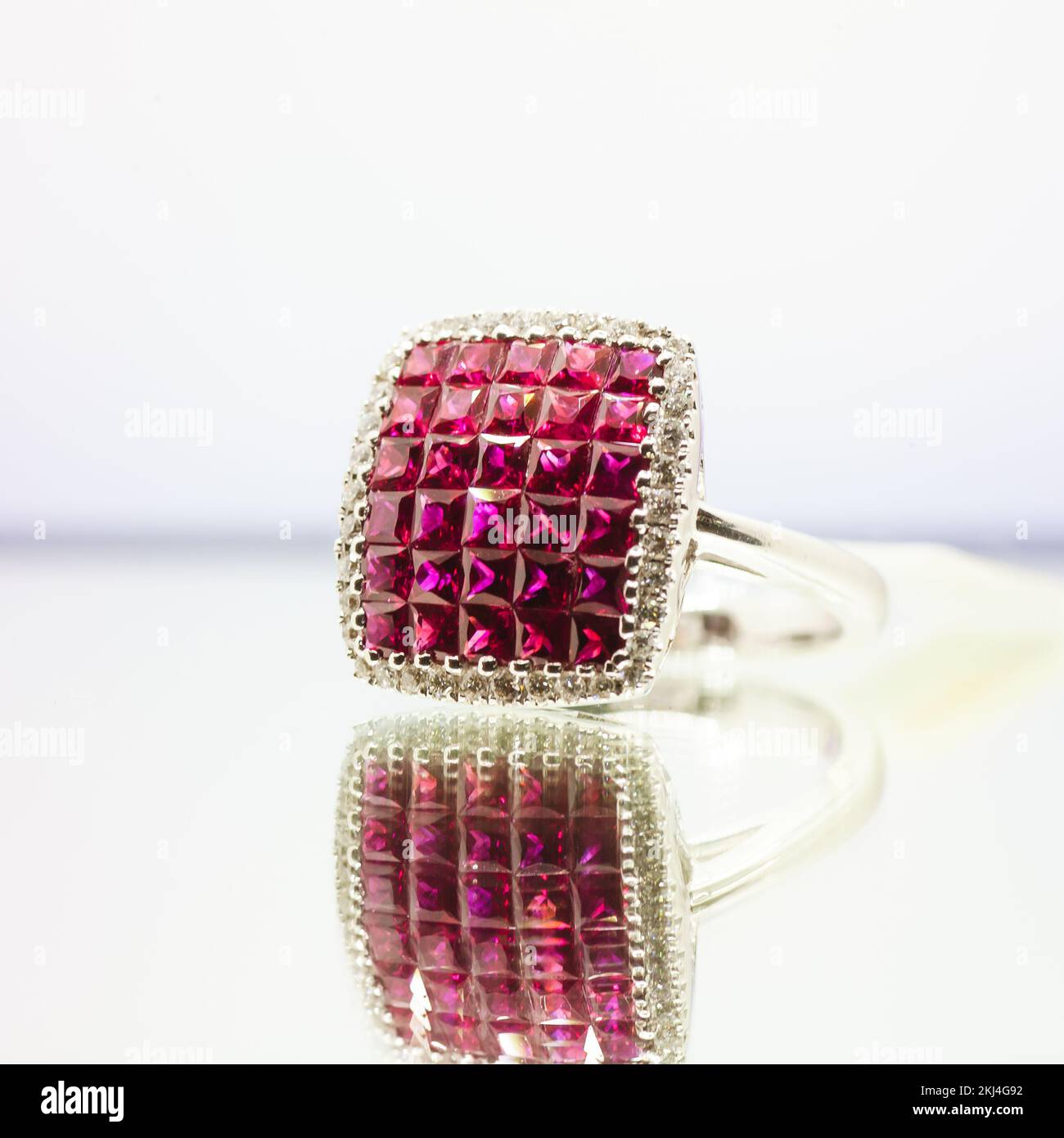 Engagement diamond ring on a mirror surface. emeralds, sapphires, and ...