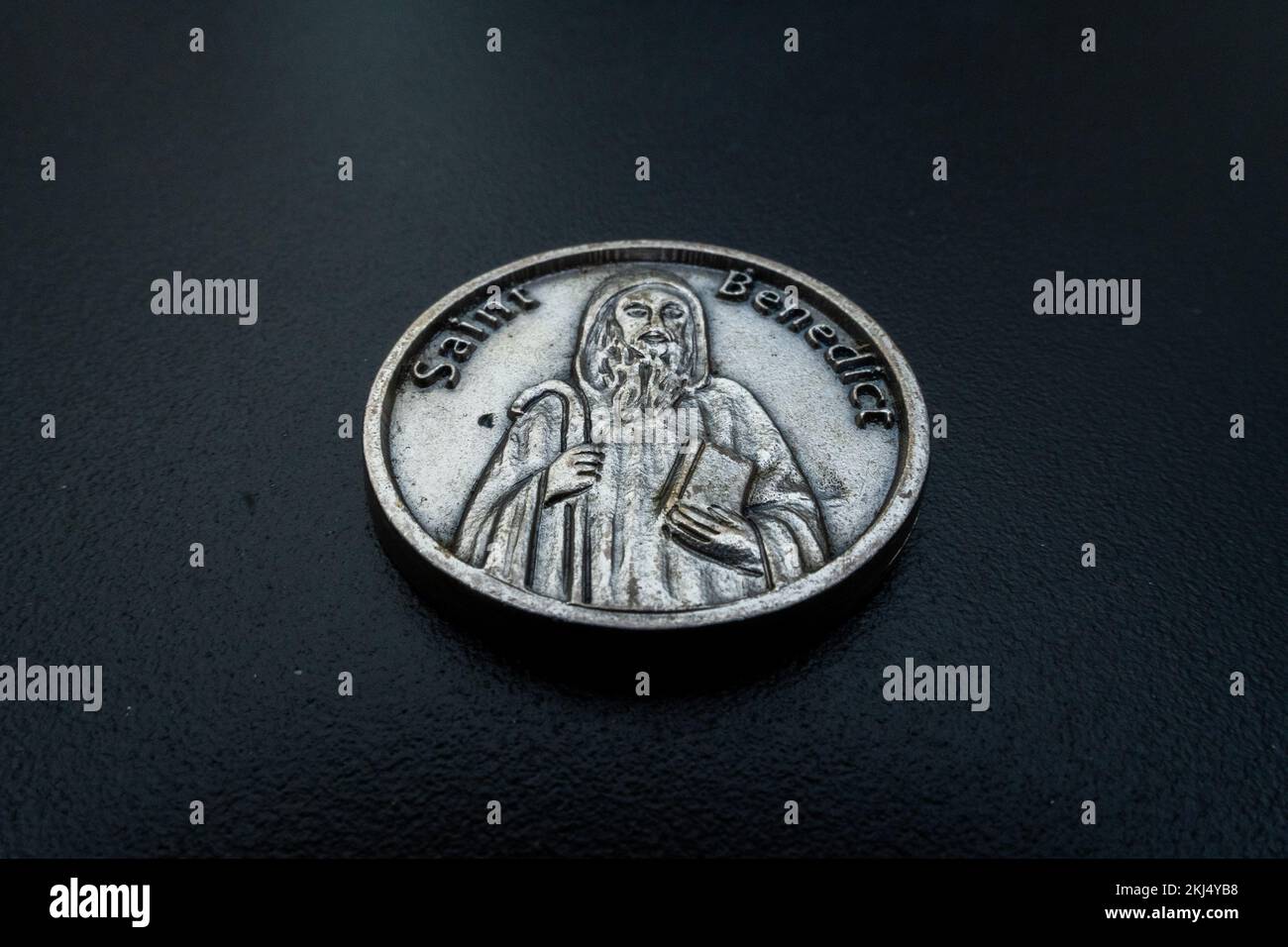 A closeup of Saint Benedict medal coin on a black background Stock ...