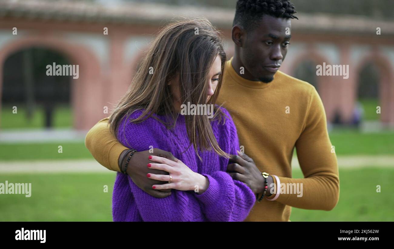 Boyfriend consoling sad girlfriend. Interracial couple, kissing ...