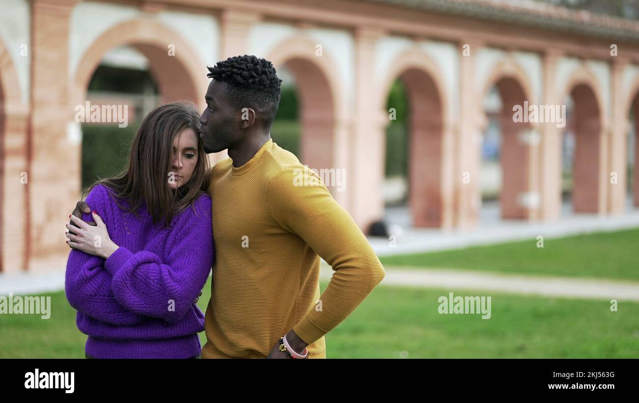Boyfriend consoling sad girlfriend. Interracial couple, kissing ...