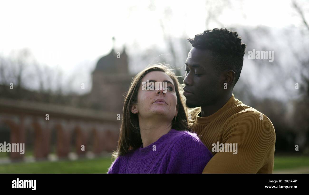 Candid interracial couple romantic moment together outside at park ...