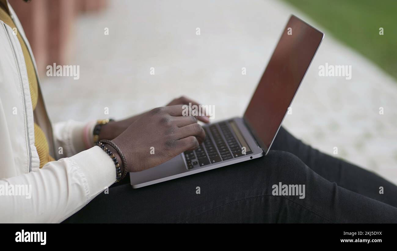 African man in front of laptop computer working remotely outside Stock ...