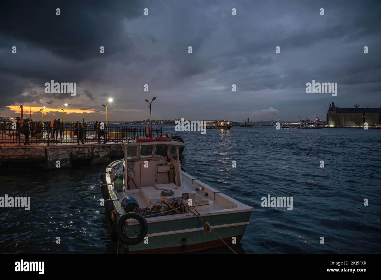 During sunset in Istanbul, a fishing boat seen at the Kadikoy dock and ...