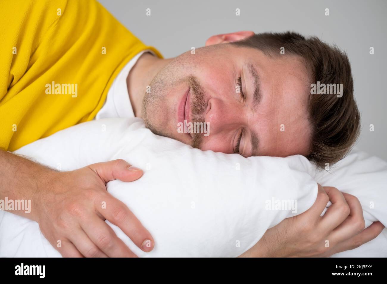 Caucasian man sleeping on pillow smiling, having rest after hardworking ...