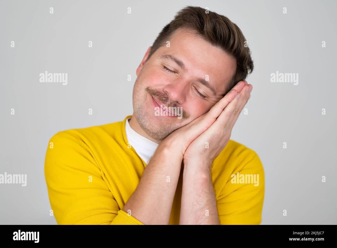 Caucasian man sleeping on pillow smiling, having rest after hardworking ...