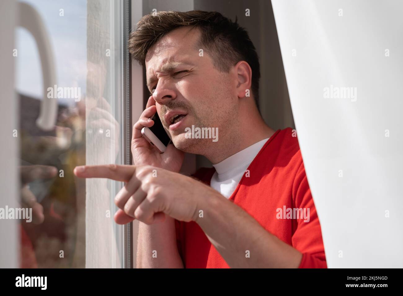 man peeking through window on accident on street. He phones to police ...