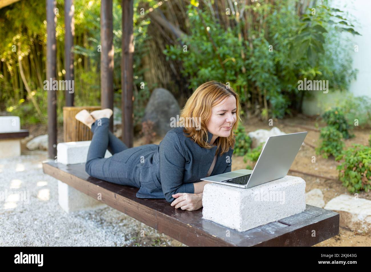A beautiful freelancer woman works at the park using a computer Stock ...