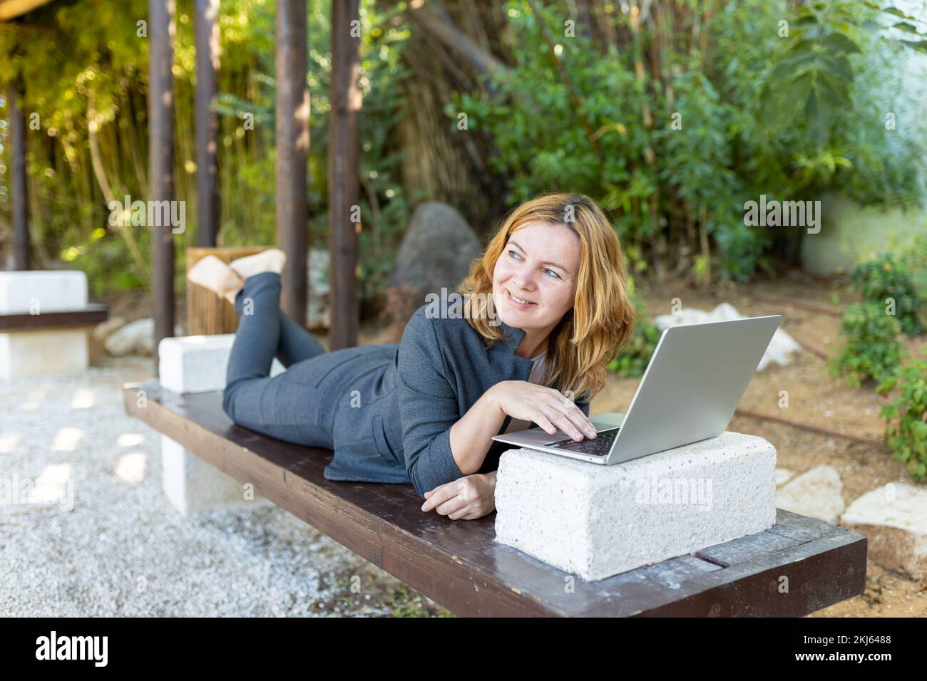 A beautiful freelancer woman works at the park using a computer Stock ...