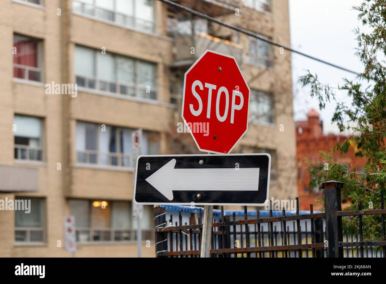 Red stop sign and arrow indicating the direction of traffic on the road ...
