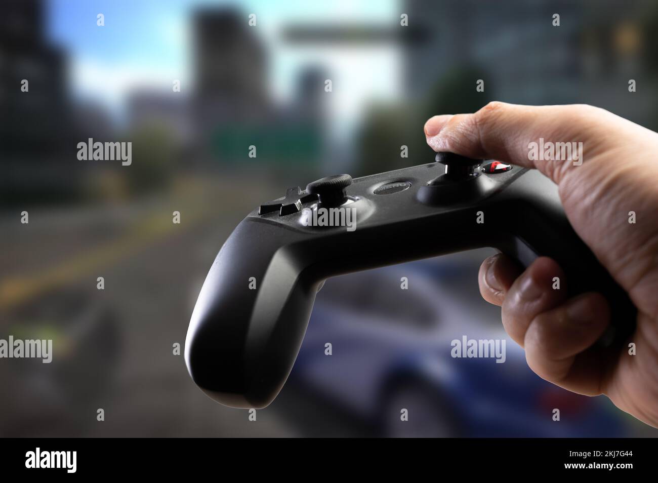 Against the backdrop of an interesting video game, a modern joystick in ...