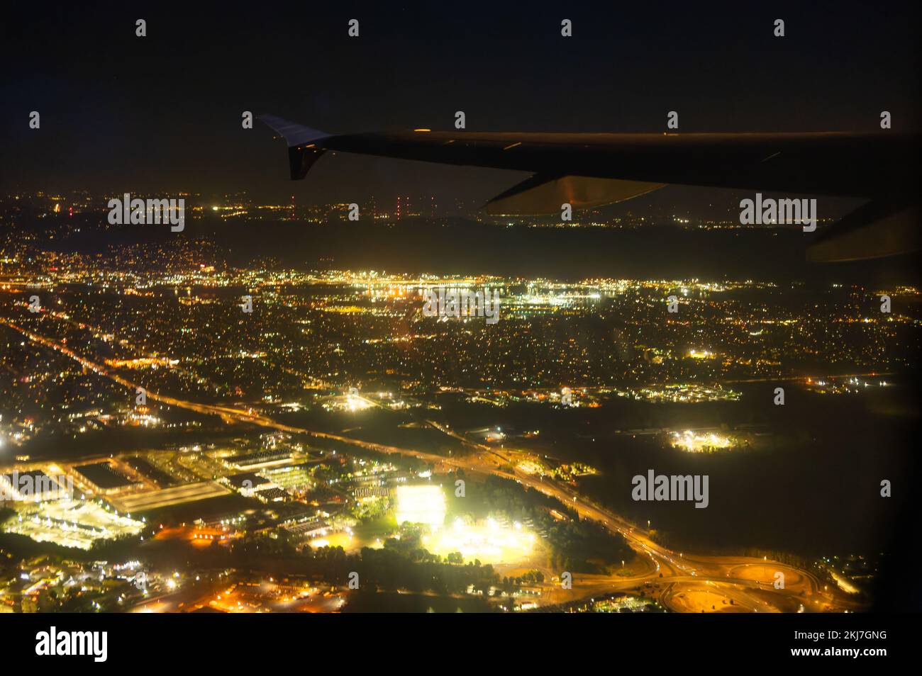 Night city from the window of the plane. Big metropolis in golden ...