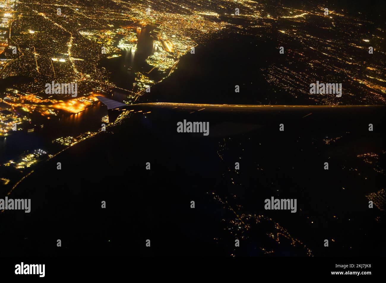 View of a large metropolis at night from the window of an airplane ...