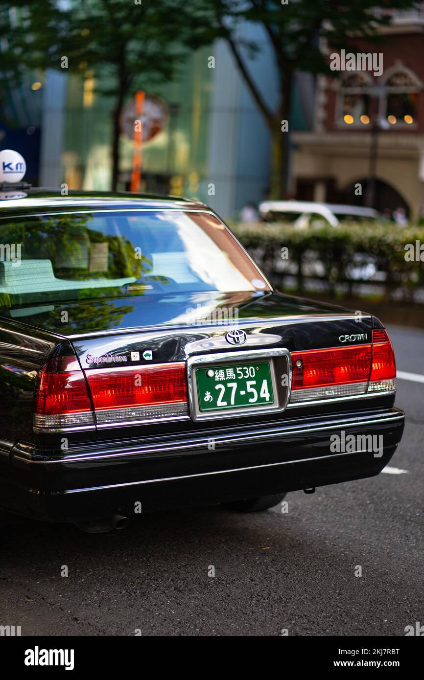 A black Toyota taxi car parked on the side of an empty street in Tokyo ...