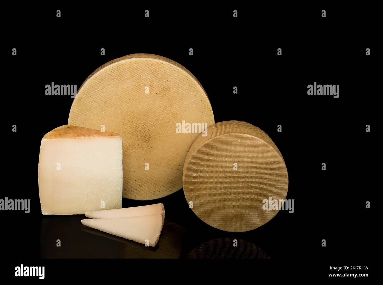 Two cheeses one large and one small isolated on a black background with ...