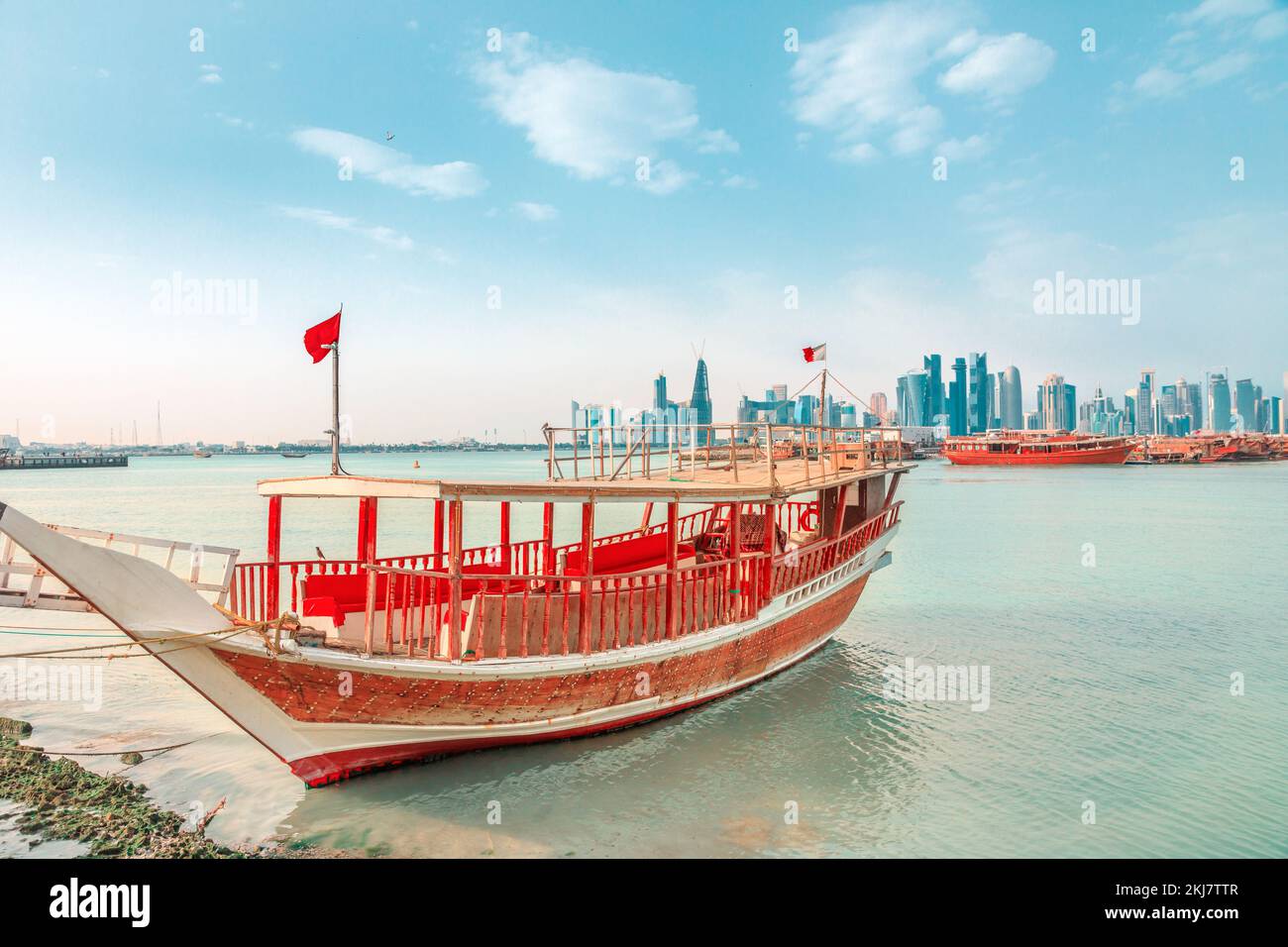Perspective view of a traditional wooden dhow in foreground with ...