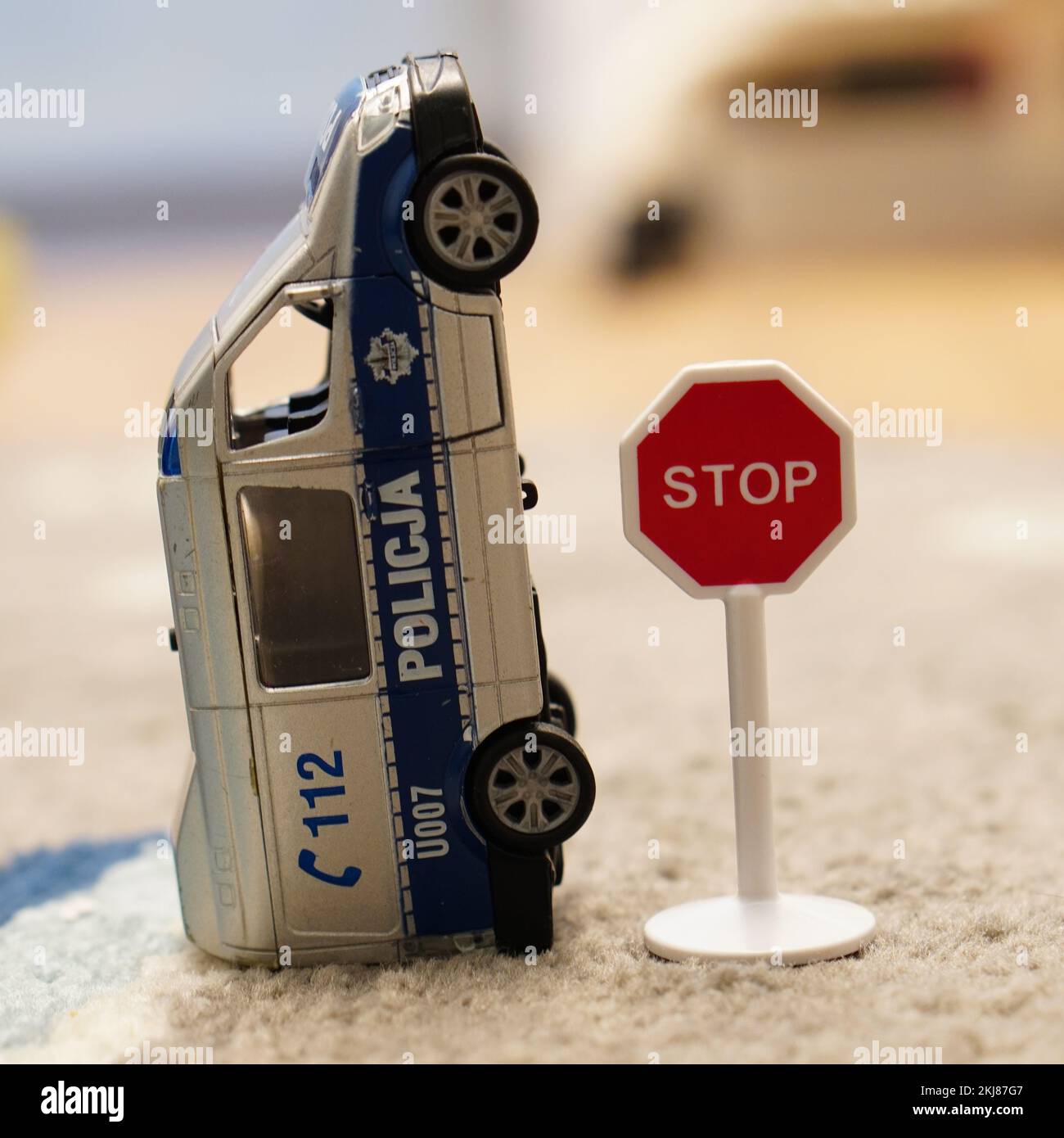 A toy model Polish police van laying upside next to a Stop sign Stock ...
