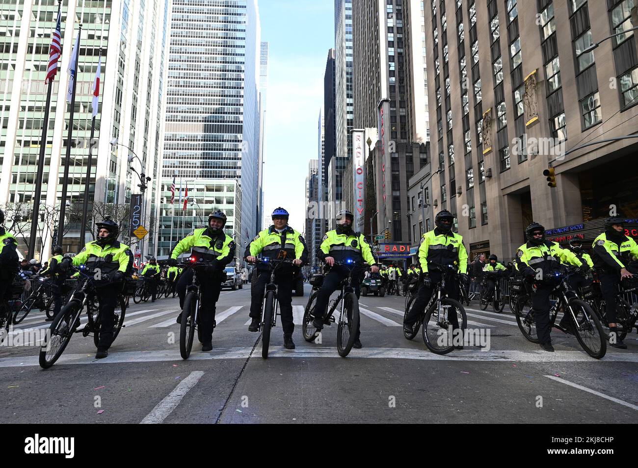 NYPD officers on bicycles ride down Avenue of the Americas during the ...