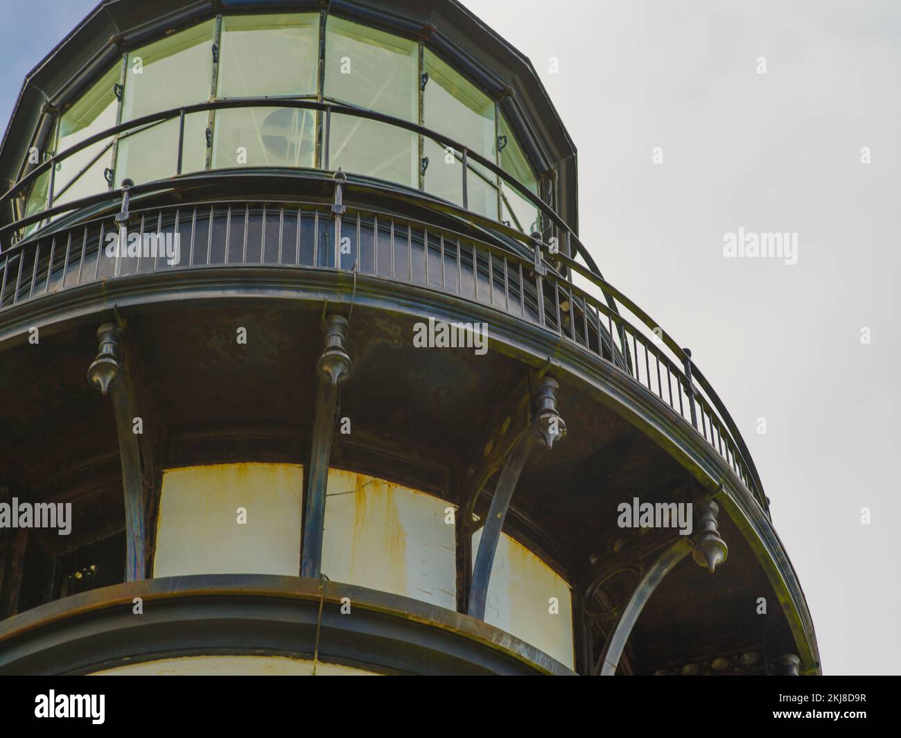 Close-up. A huge tower of a high lighthouse against a cloudy sky ...