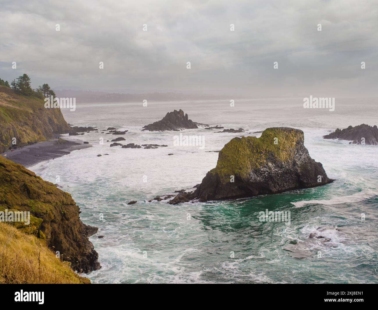 A tall white lighthouse with a window against a blue cloudy sky ...