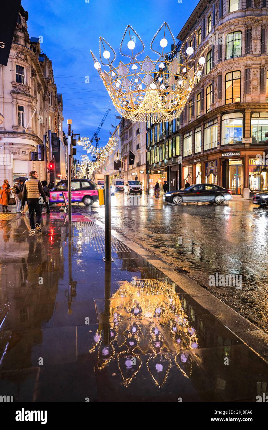 London, UK. 24th Nov, 2022. A large illuminated crown is reflected in ...