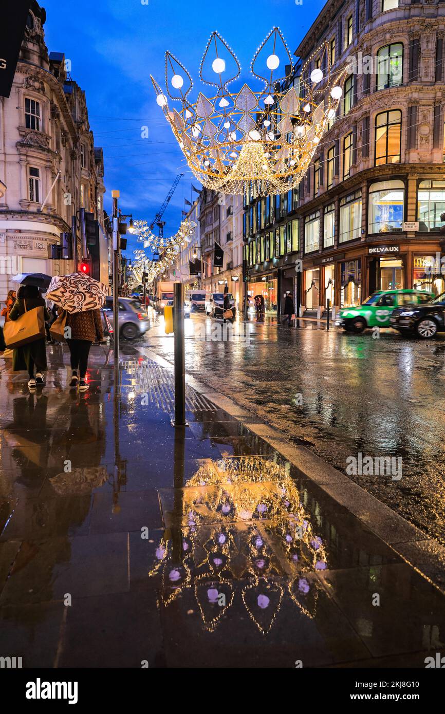 London, UK. 24th Nov, 2022. A large illuminated crown is reflected in ...