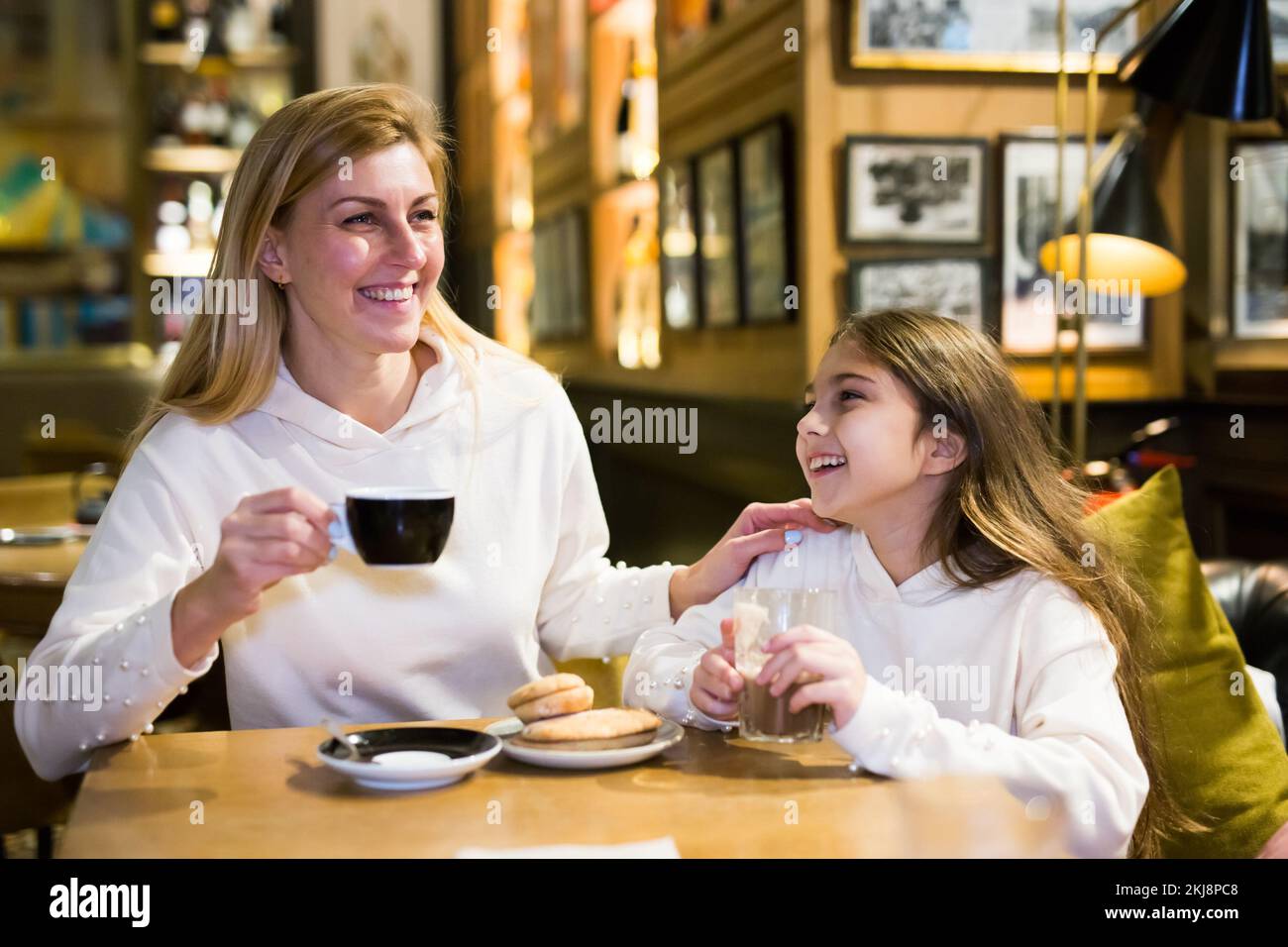 Mom and daughter drink morning coffee in cafe Stock Photo - Alamy