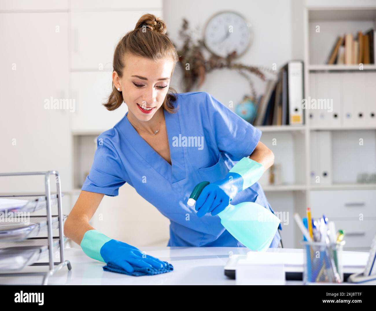 Female cleaning service worker wiping working table in office Stock ...