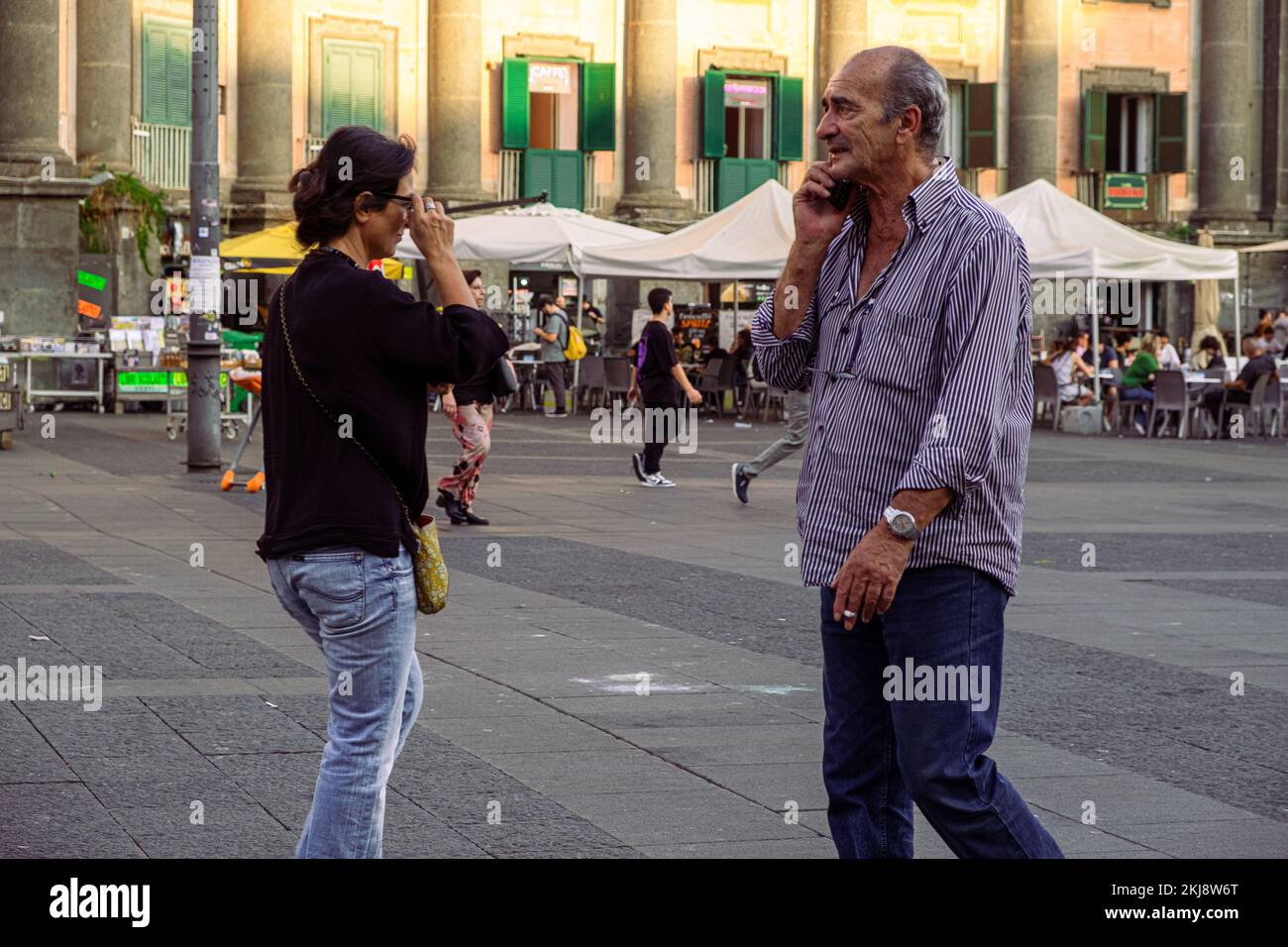 Two people walking in opposite directions at Dante's Square in Naples ...