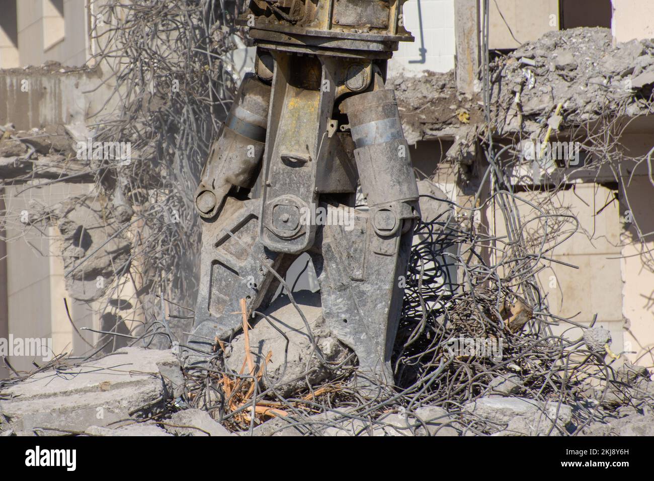 Hydraulic shears of heavy machinery on the background of the destroyed ...
