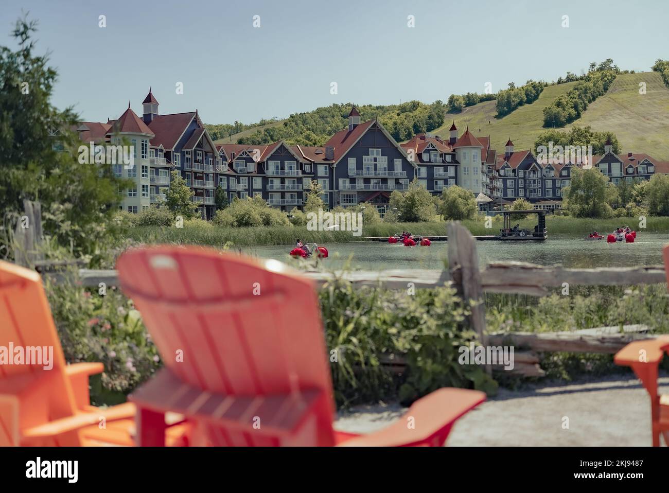 A terrace with folding beach chairs with a view of a lake, houses and a ...