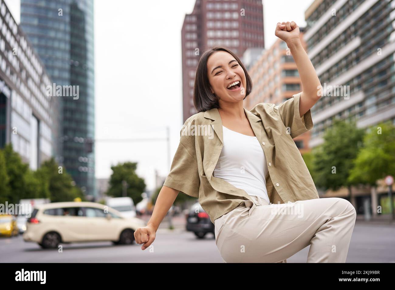 Portrait of happy asian woman, dancing and feeling joy, triumphing ...