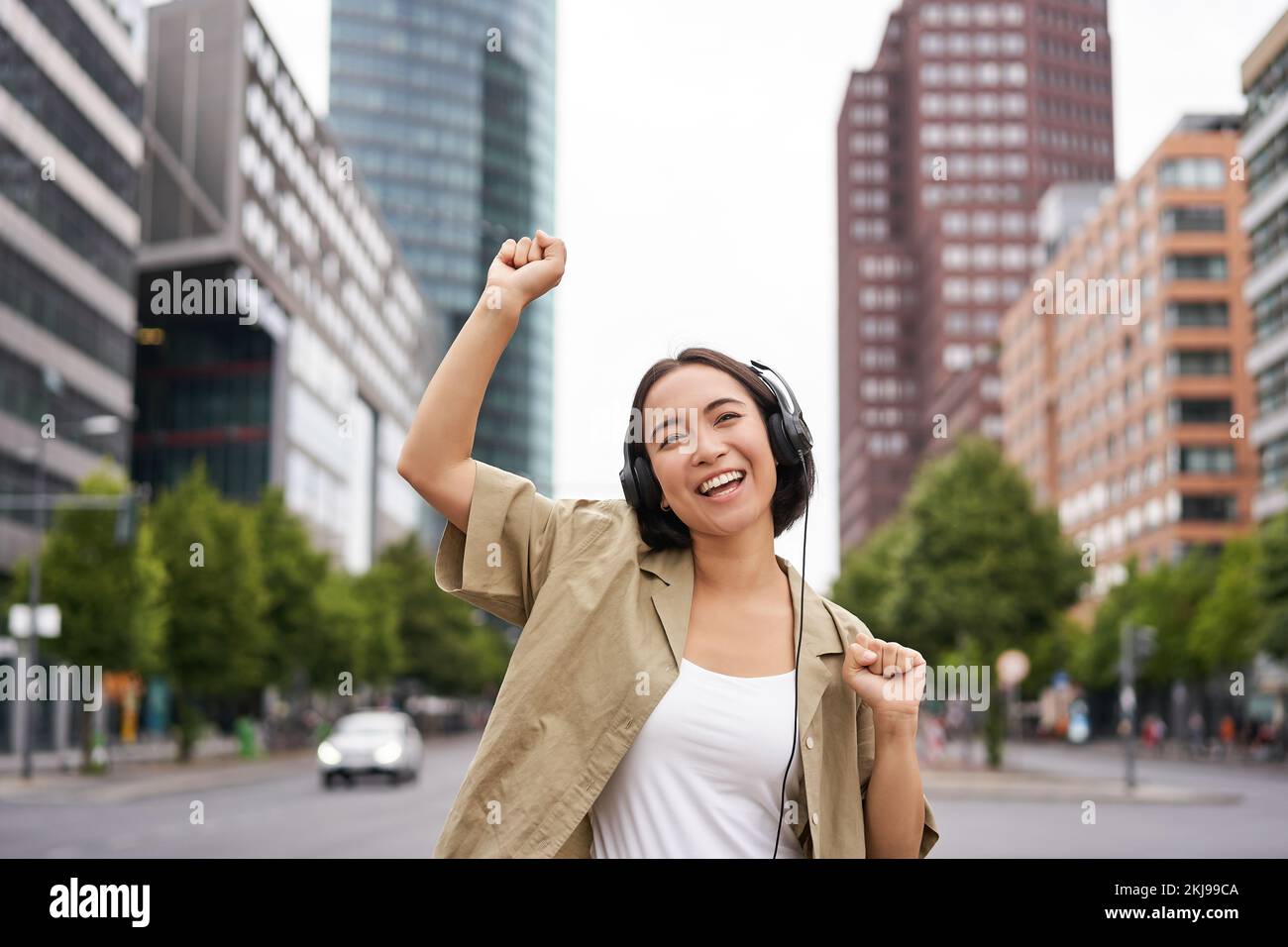 Portrait of smiling asian woman dancing, triumphing, feeling happy ...