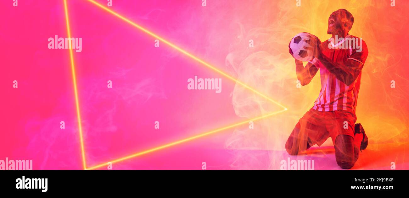 African american male soccer player with ball kneeling and screaming by ...