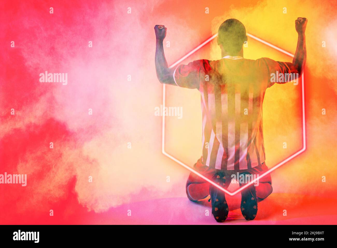 African american male soccer player with arms raised kneeling by ...