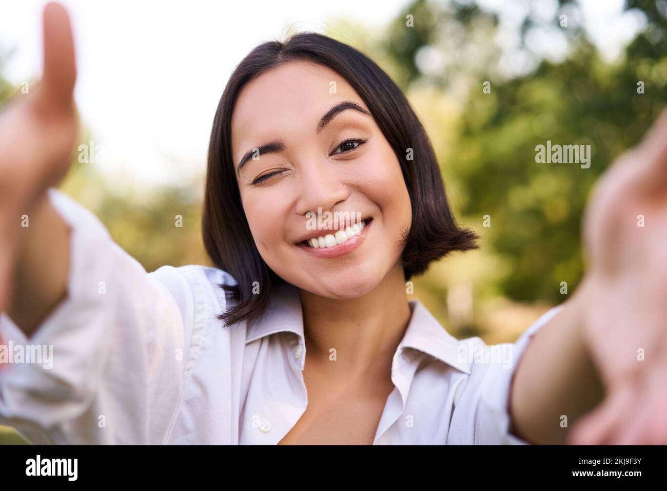 People and mobile connection. Happy young asian woman takes selfie on ...