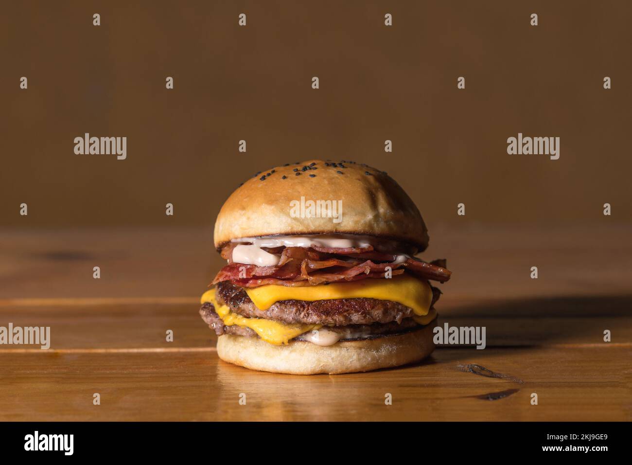 A cheeseburger on a wooden table Stock Photo - Alamy