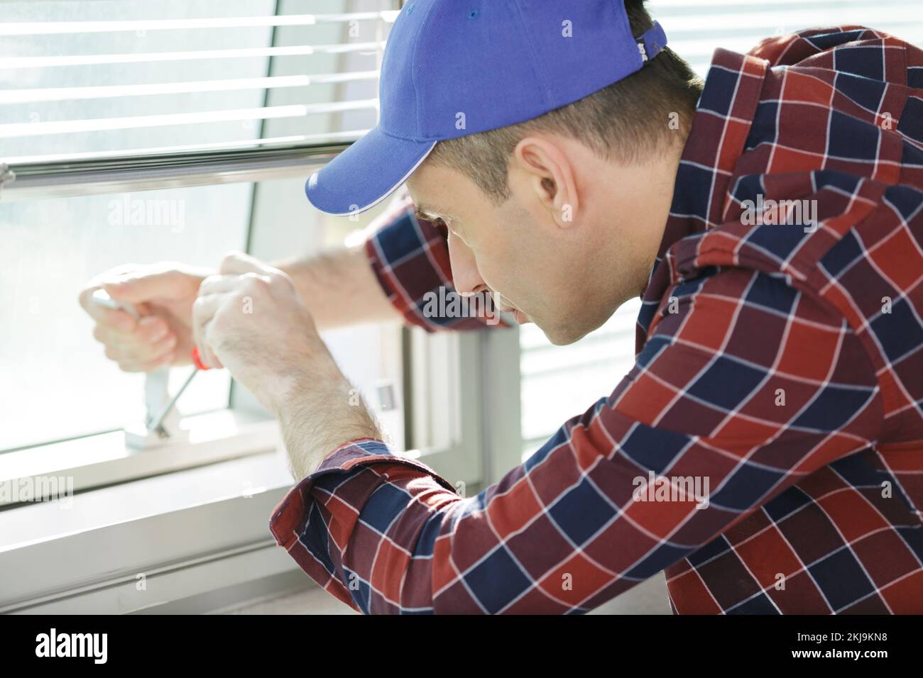 man drilling the window with impact drill Stock Photo - Alamy