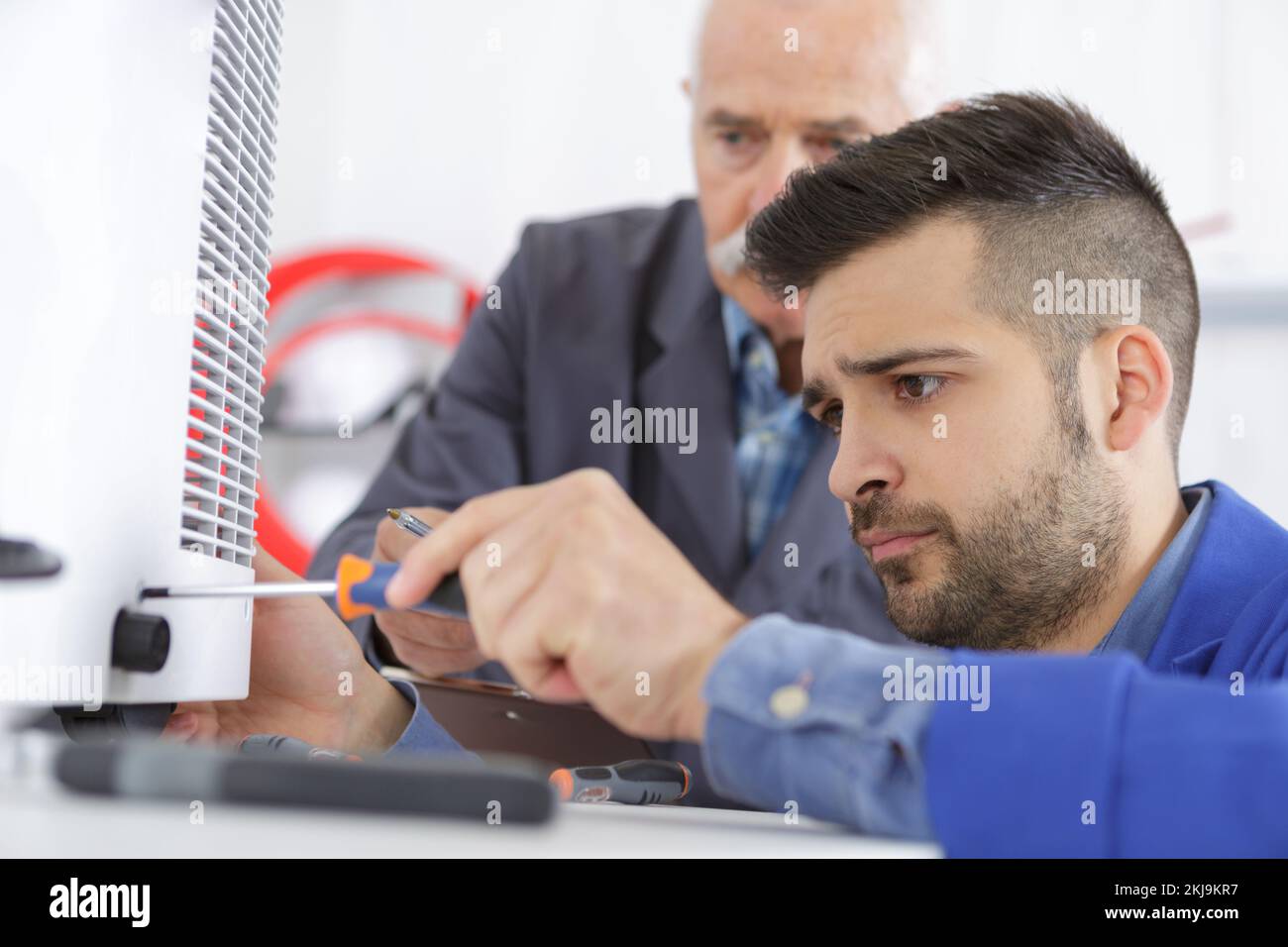 concentrated engineer fixing an electronic device Stock Photo - Alamy