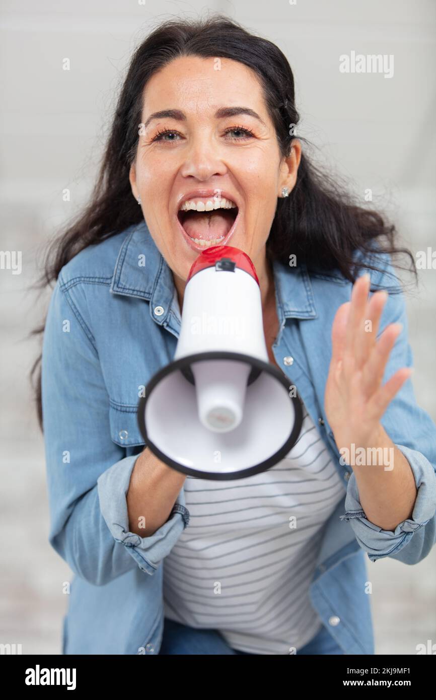 excited mature woman talking into a megaphone Stock Photo - Alamy