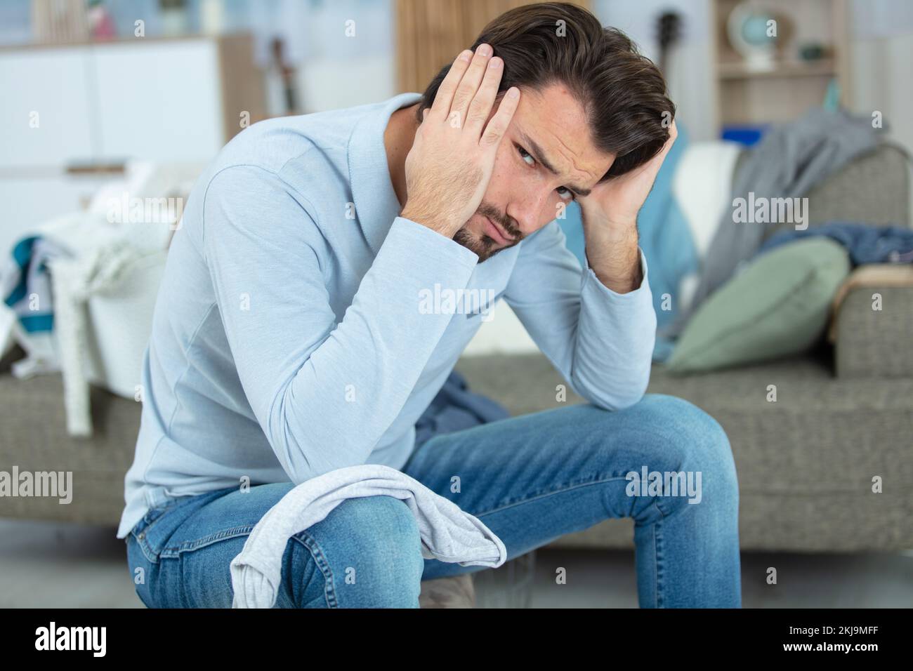 young man suffering from headache after hard working day Stock Photo ...