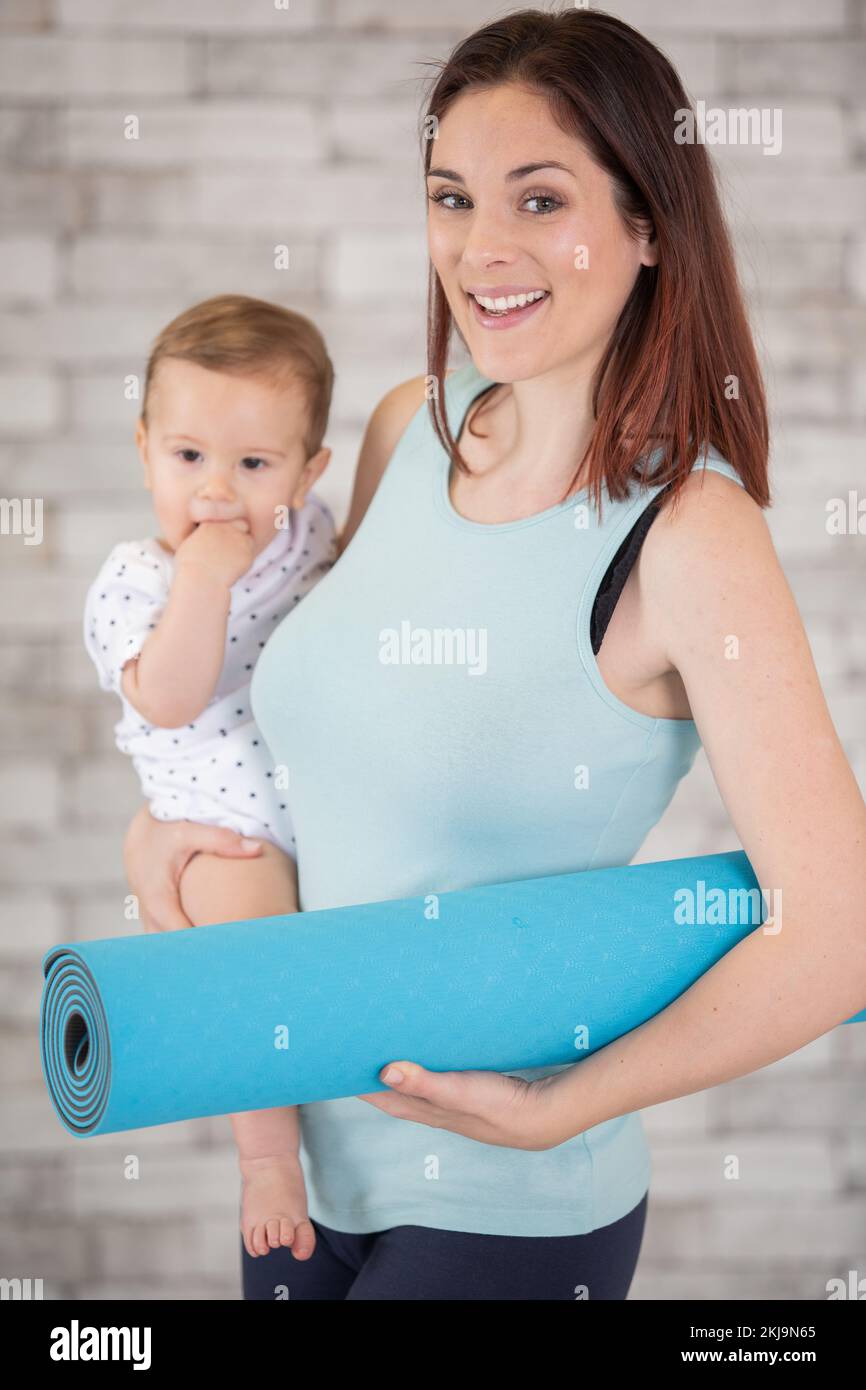 happy charming sporty mother holding cute little baby Stock Photo - Alamy