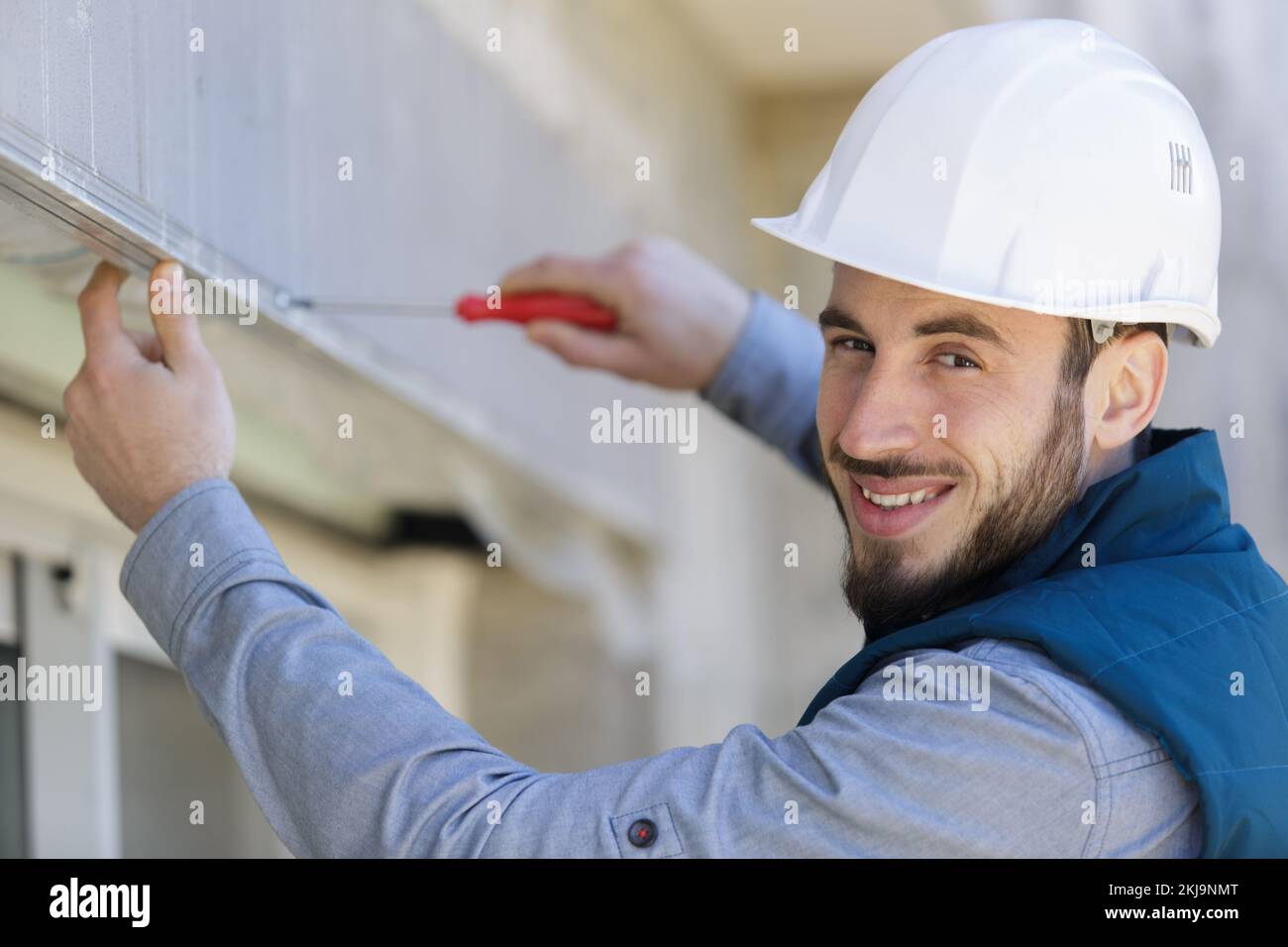 hand with screwdriver tighten the screw stopper window Stock Photo - Alamy