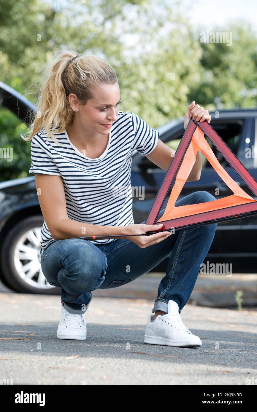young woman setting the safety triangle Stock Photo - Alamy