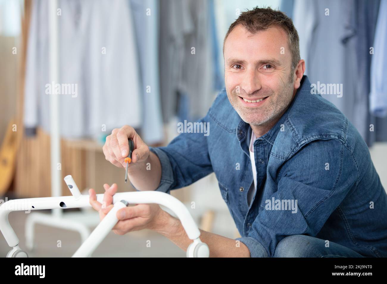 happy man assembling a metal chair with allen-key Stock Photo - Alamy