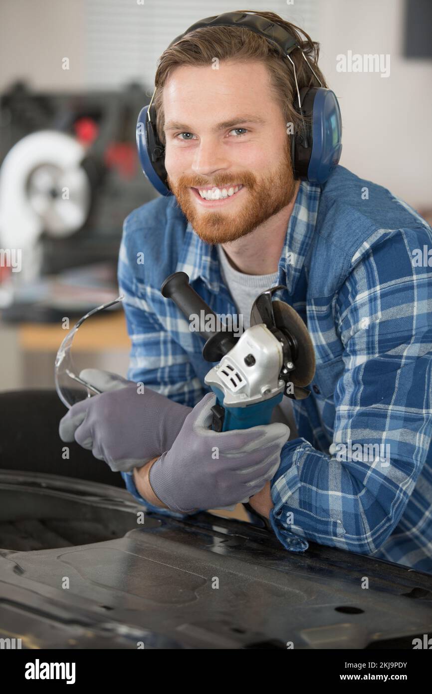 portrait of a young man holding an angle grinder Stock Photo - Alamy