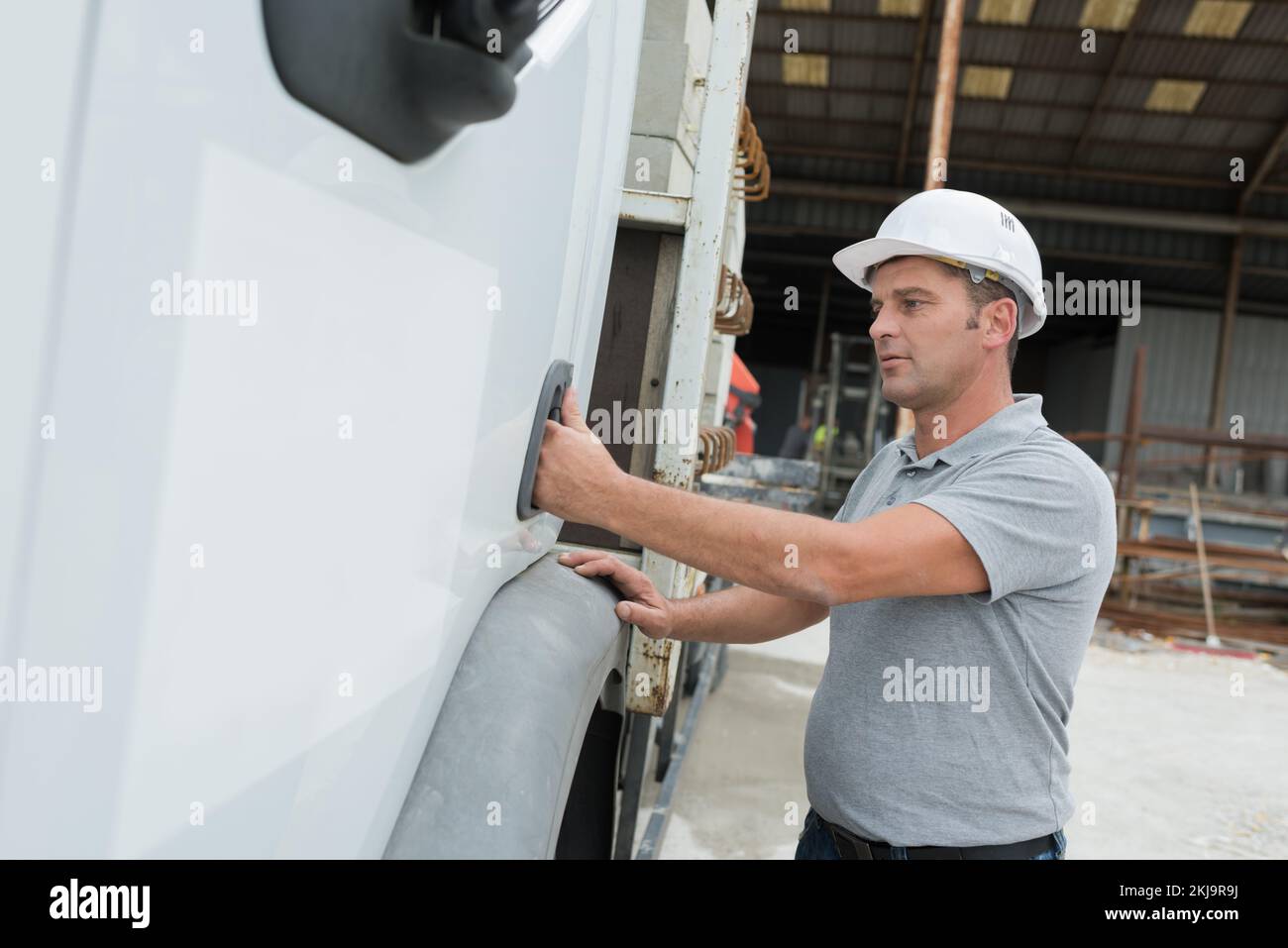 male worker next to lorry Stock Photo - Alamy