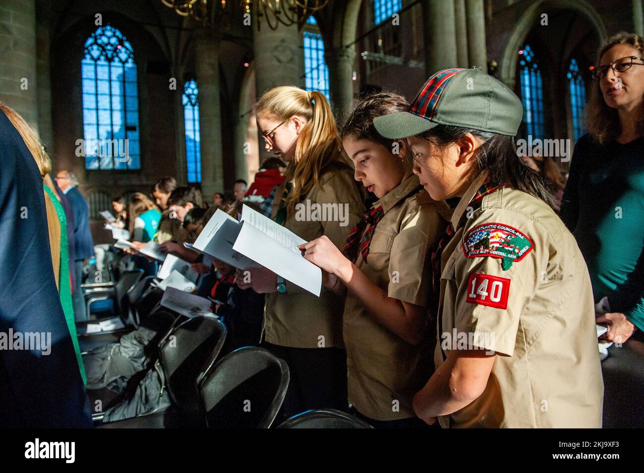 Boy scouts are seen reading the program of the ceremony. After the ...