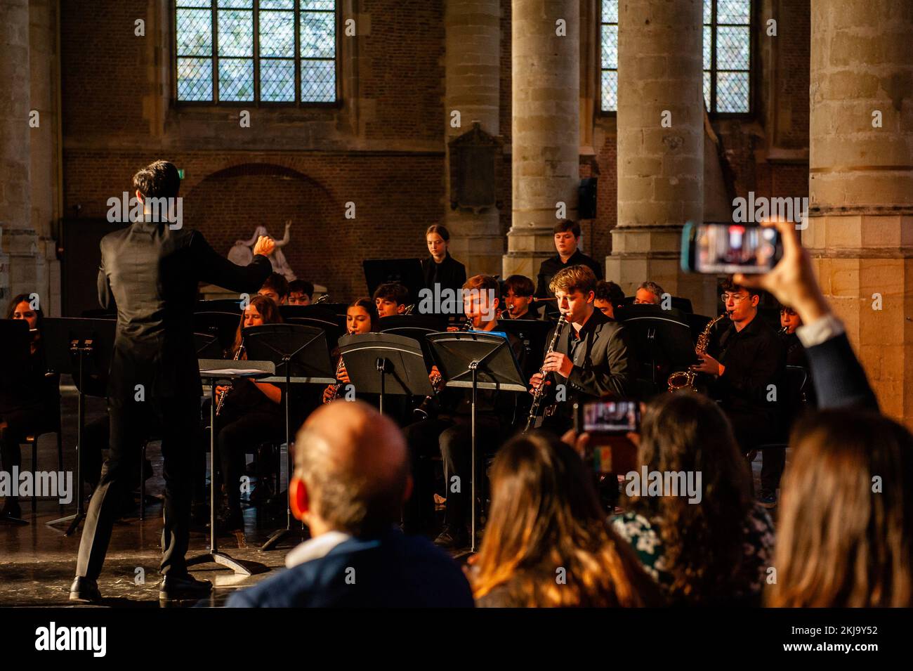 People are seen sitting while taking photos of a band playing music ...