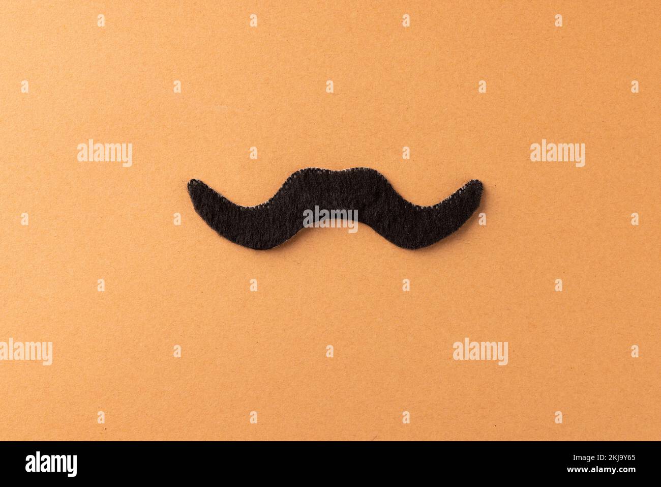 Composition of fake black moustache on orange background with copy ...